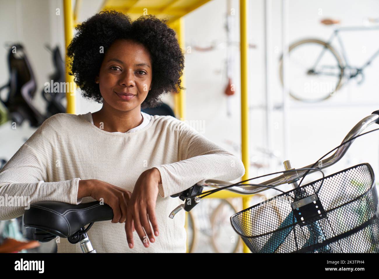 Portrait of African-American woman shop owner standing in her bicycle ...