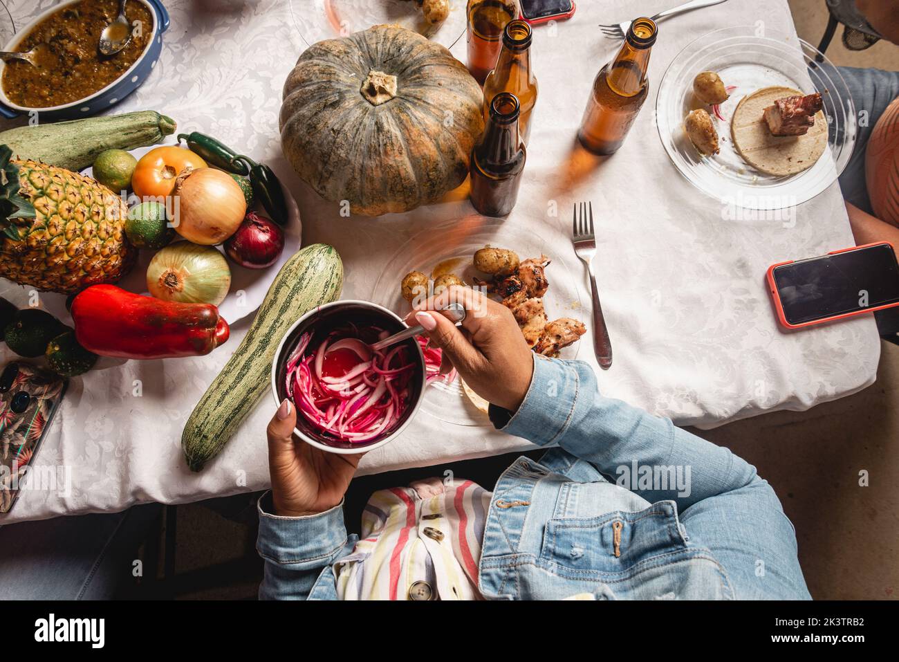 From above of crop anonymous group of friends eating tasty meal while ...