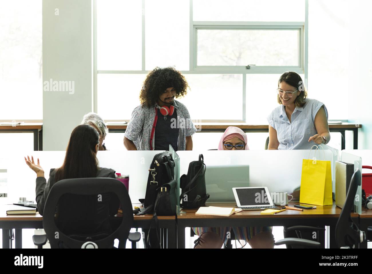 Group of cheerful multiracial coworkers discussing project during work ...
