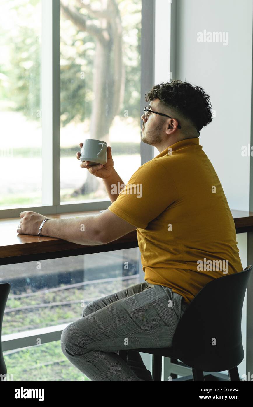 Side view of male employee drinking beverage while having coffee break ...
