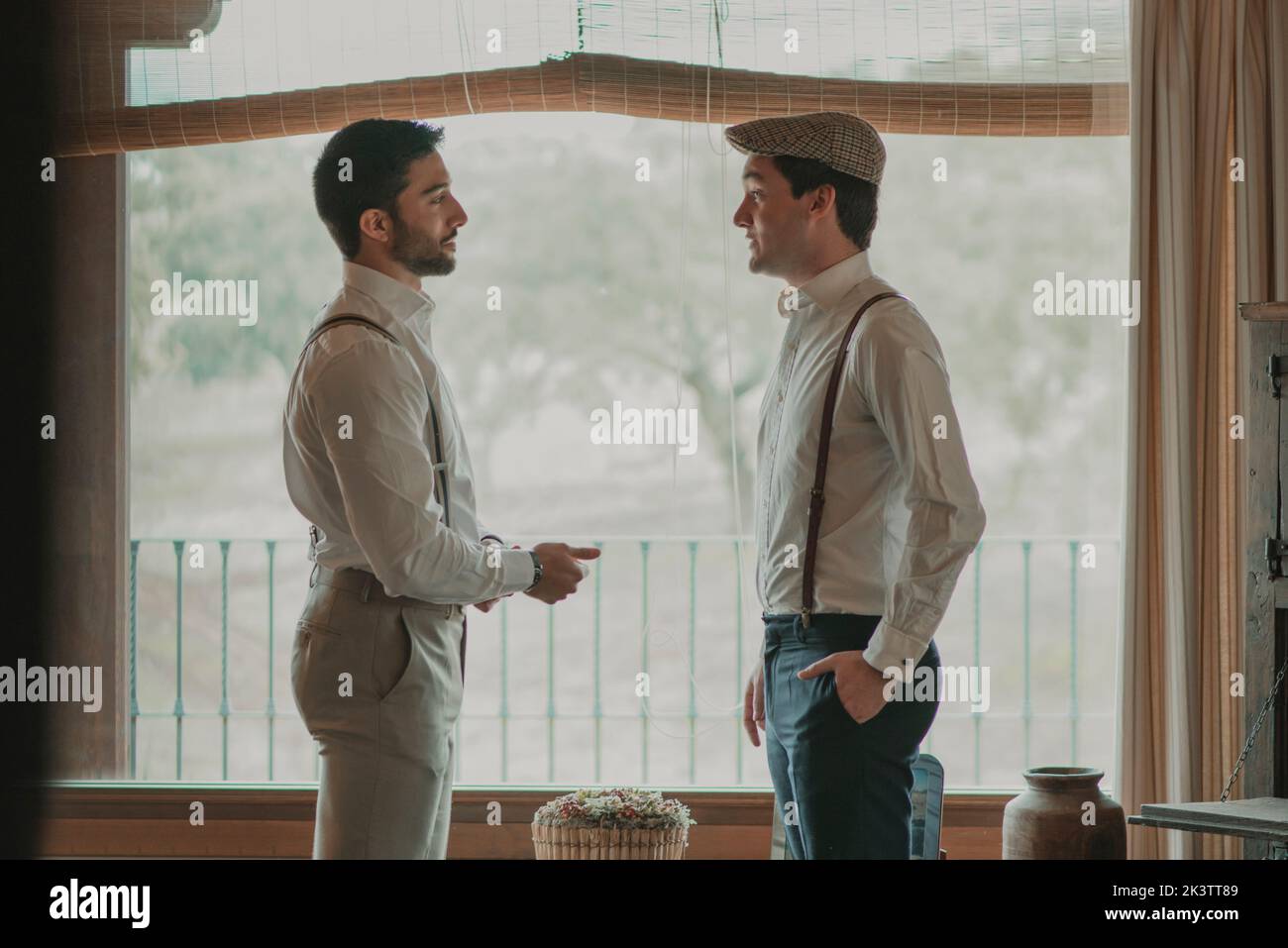 Side view of handsome guys in shirts and trousers with suspenders ...