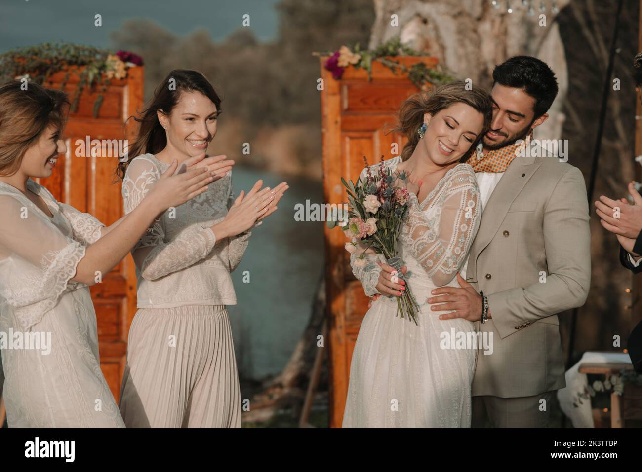 Young guy in grey costume hugging attractive smiling lady in wedding ...