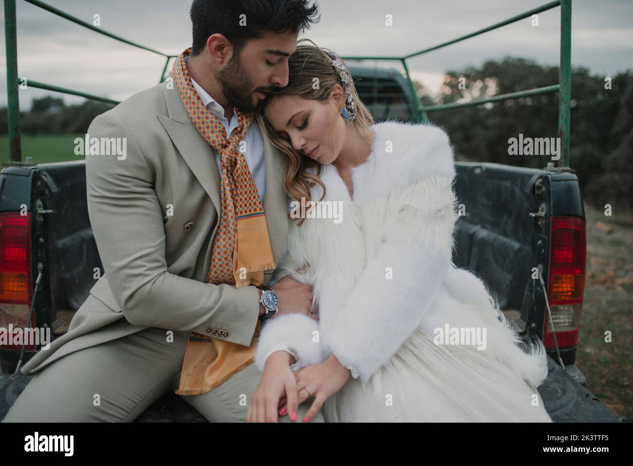 Young guy in suit sitting near attractive lady in wedding dress with ...