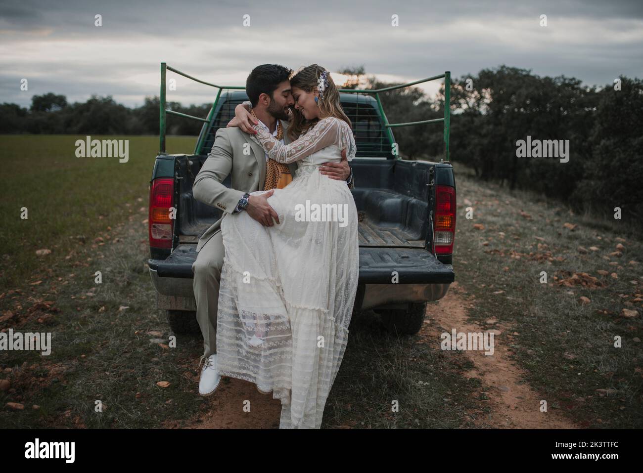 Young guy in suit sitting near attractive lady in wedding dress with ...
