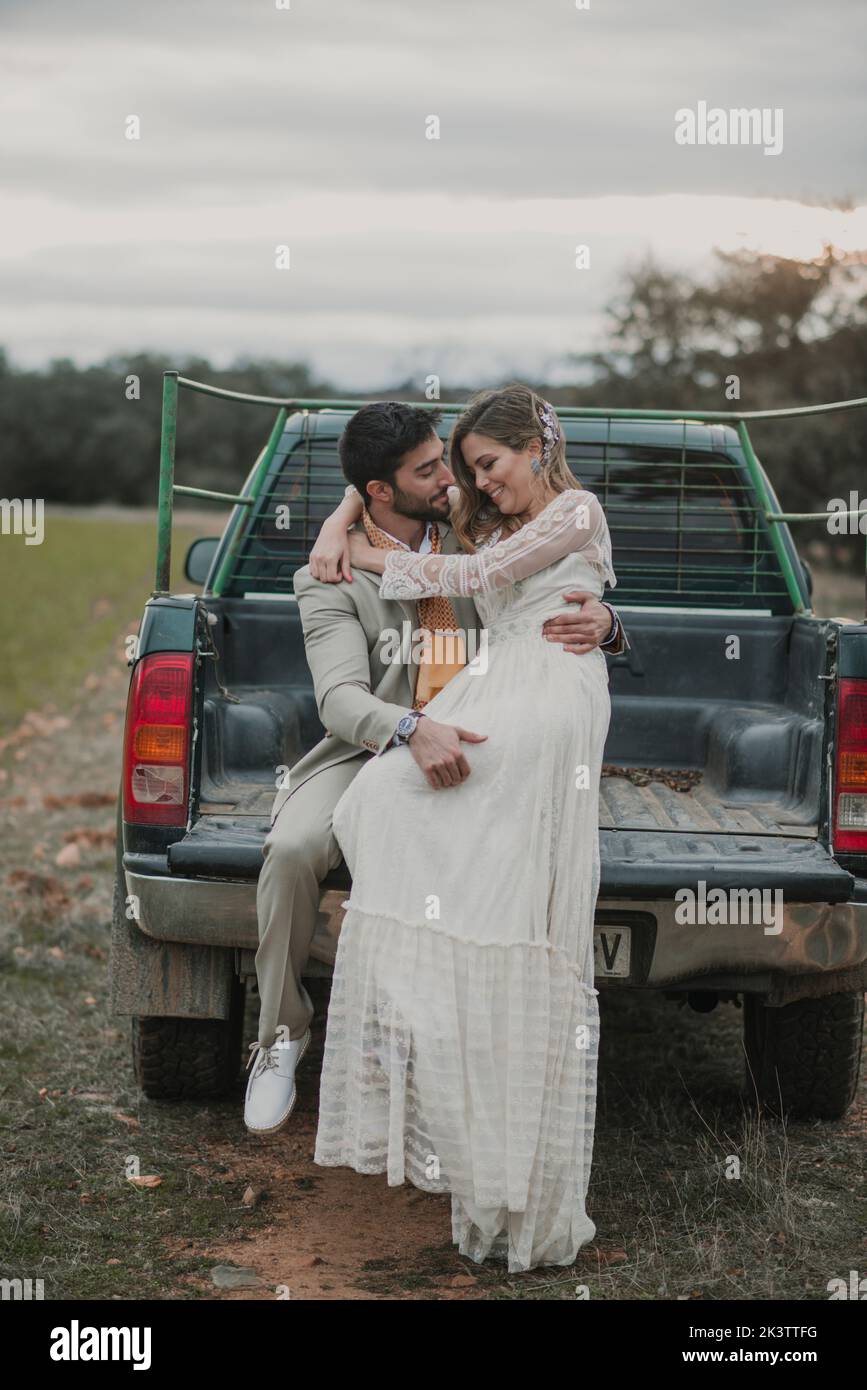 Young guy in suit sitting near attractive lady in wedding dress with ...
