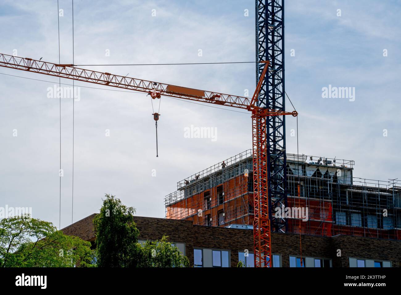 Large cranes for construction of an apartment building Stock Photo - Alamy