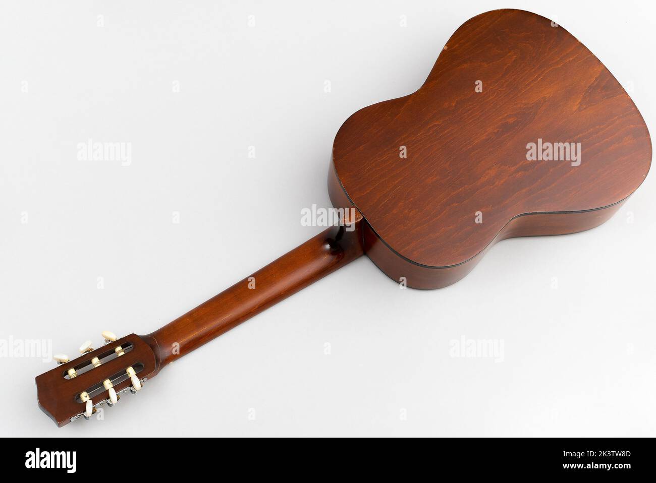 The back of an old dark red burgundy acoustic western guitar isolated ...