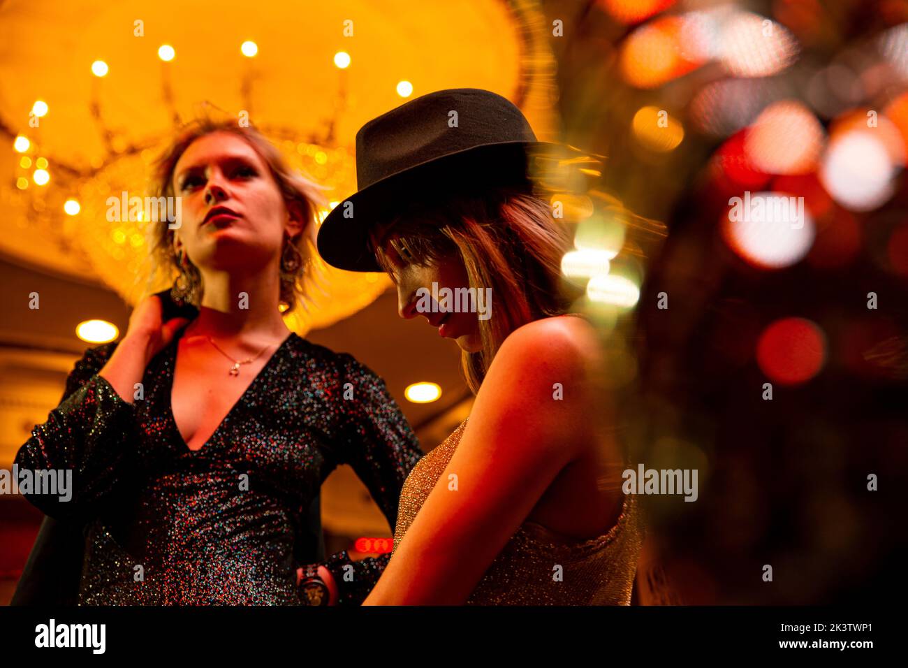 Low angle side view of female in stylish dress dancing in illuminated ...