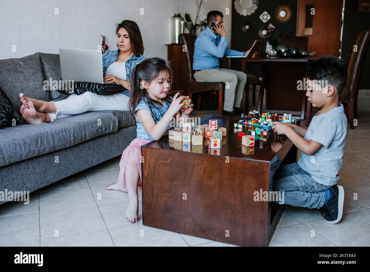 Full body of adorable ethnic sibling sitting on floor and playing with ...