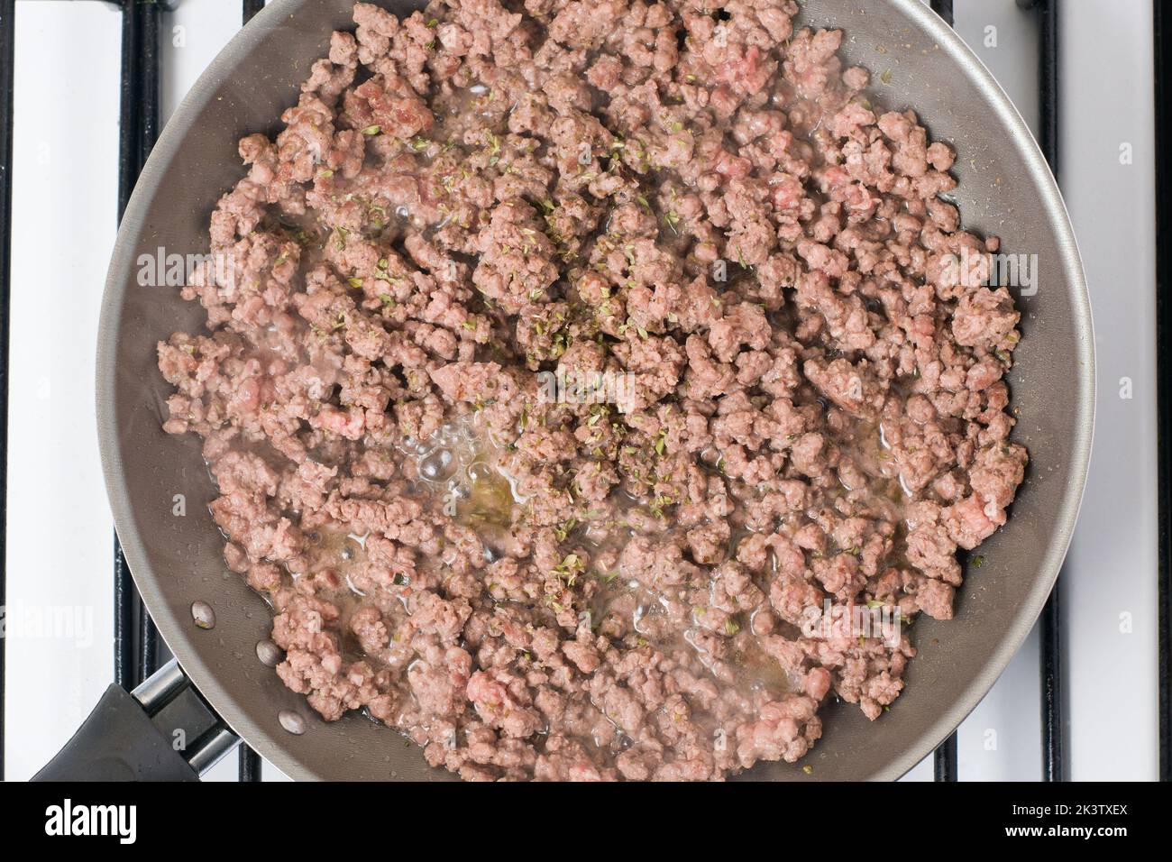 Top view of ground beef with condiments frying on pan for cooking lunch ...