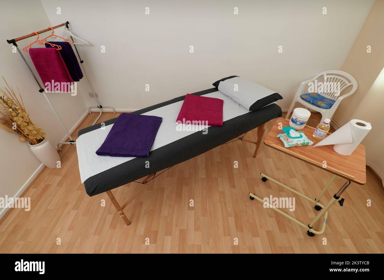 Massage table, towels, table, and massage equipment set up in room ...