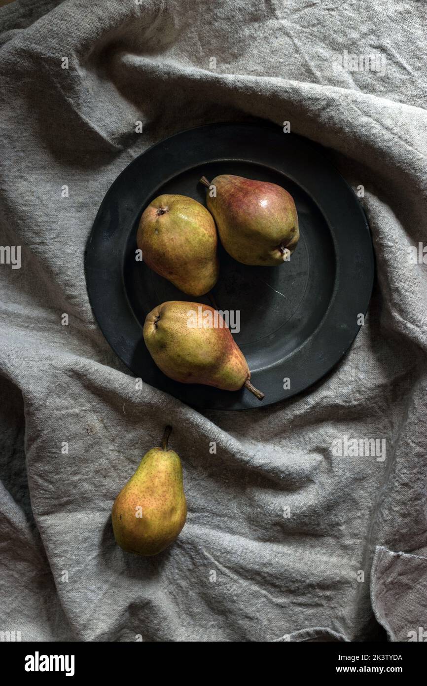 Top view of composed heap of fresh shiny pears with red and orange skin ...