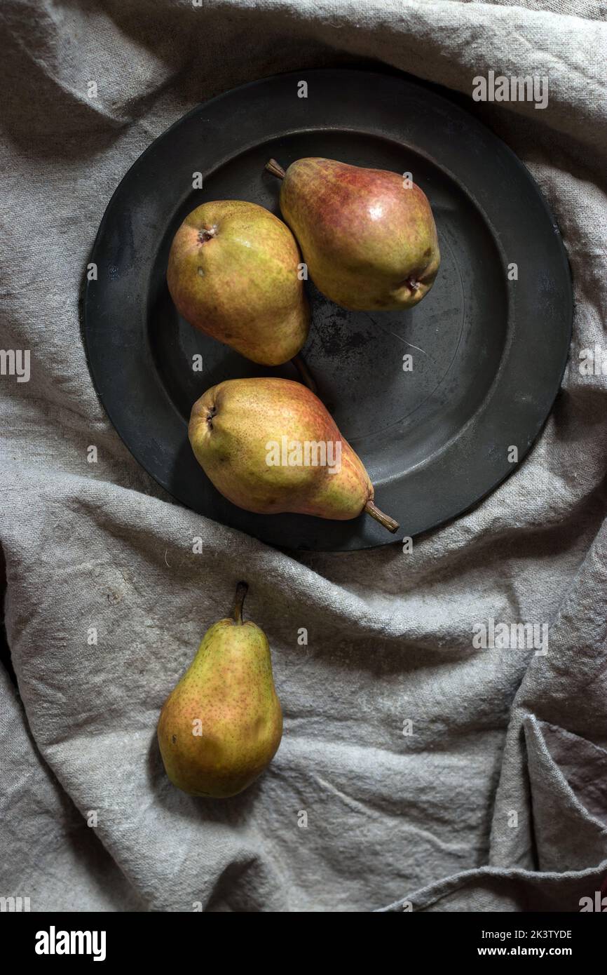 Top view of composed heap of fresh shiny pears with red and orange skin ...