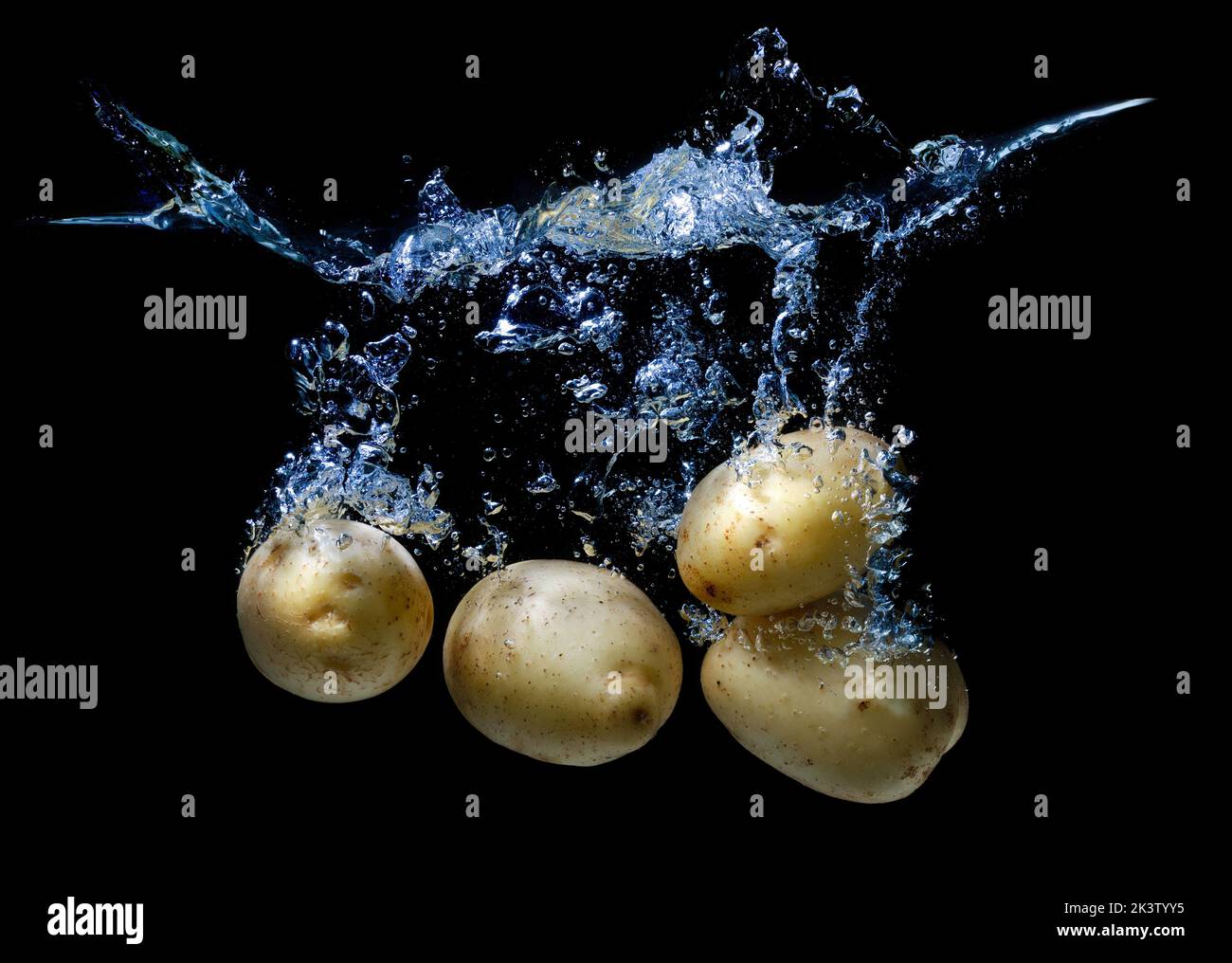 Bunch of fresh potatoes thrown underwater with splashes isolated on ...