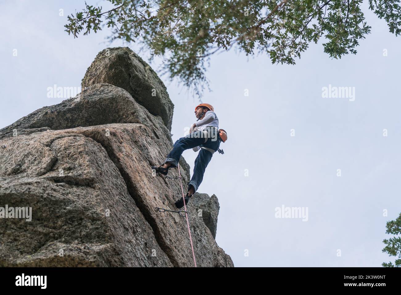 Side view of sportive male alpinist ascending on cliff in mountain ...