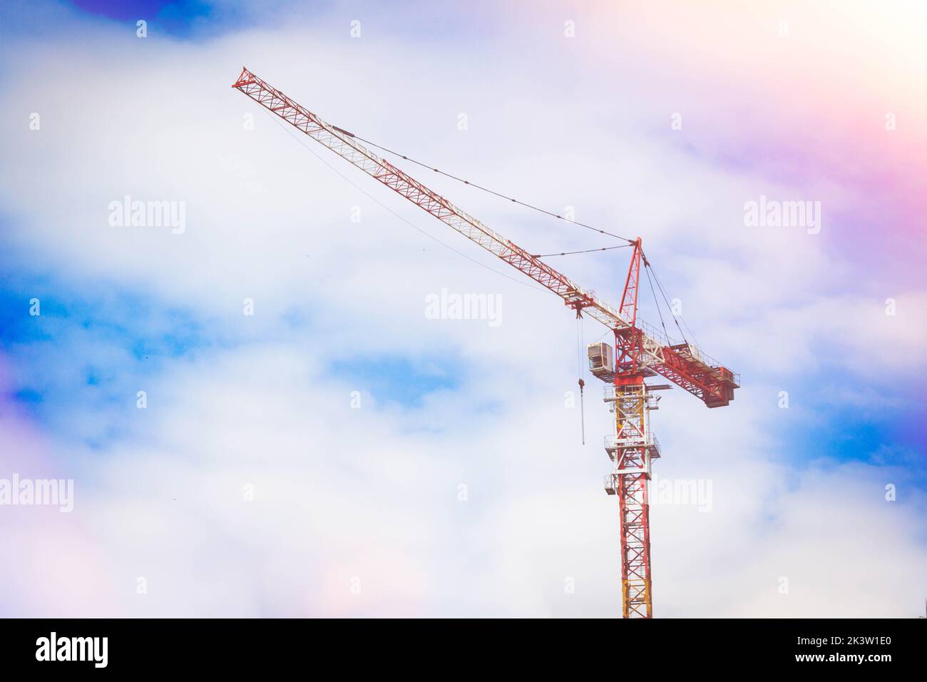 Construction crane in rays of bright sun. House under construction and ... Construction crane in rays of bright sun. House under construction and ...