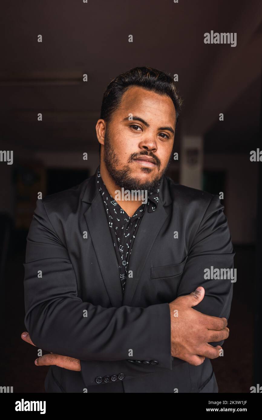 Self assured black male with beard in elegant suit standing looking at ...