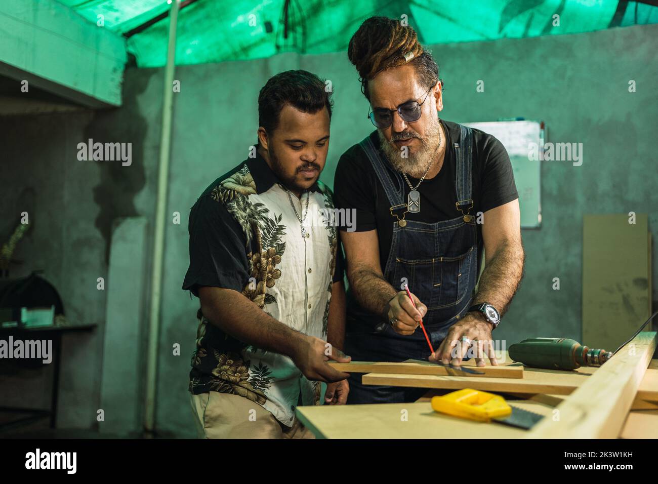 Serious multiracial male colleagues with ruler measuring wooden plank ...