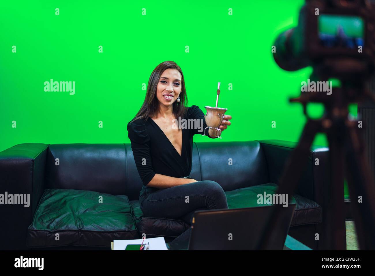 Positive female blogger demonstrating yerba mate cup with metal straw ...