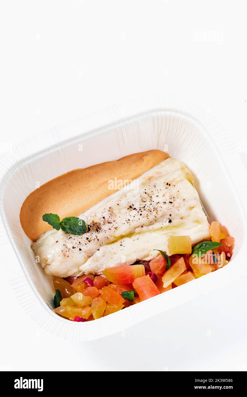 Sea Bass Fillet with tomato salad and sauce in a plastic takeout ...
