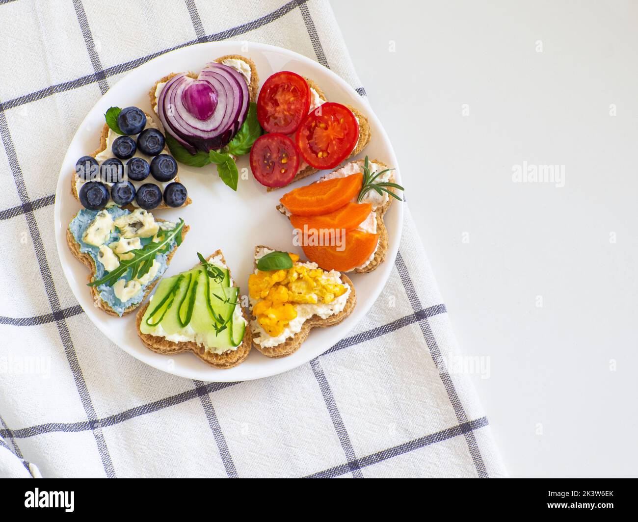 Rainbow sandwiches heart shape on white table. Breakfast bread rainbow ...