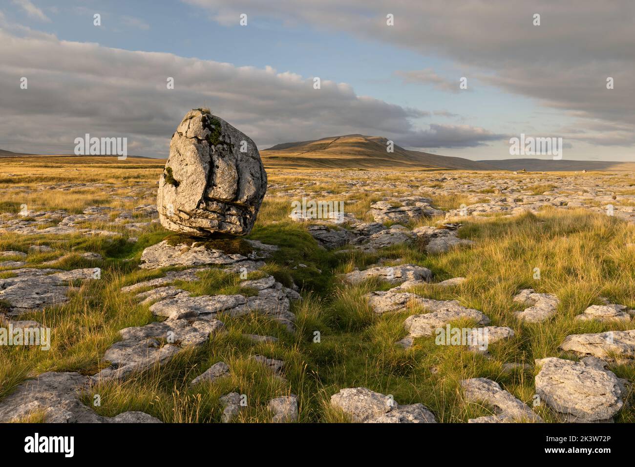 A large boulder standing on limestone pavement, on the slopes of ...
