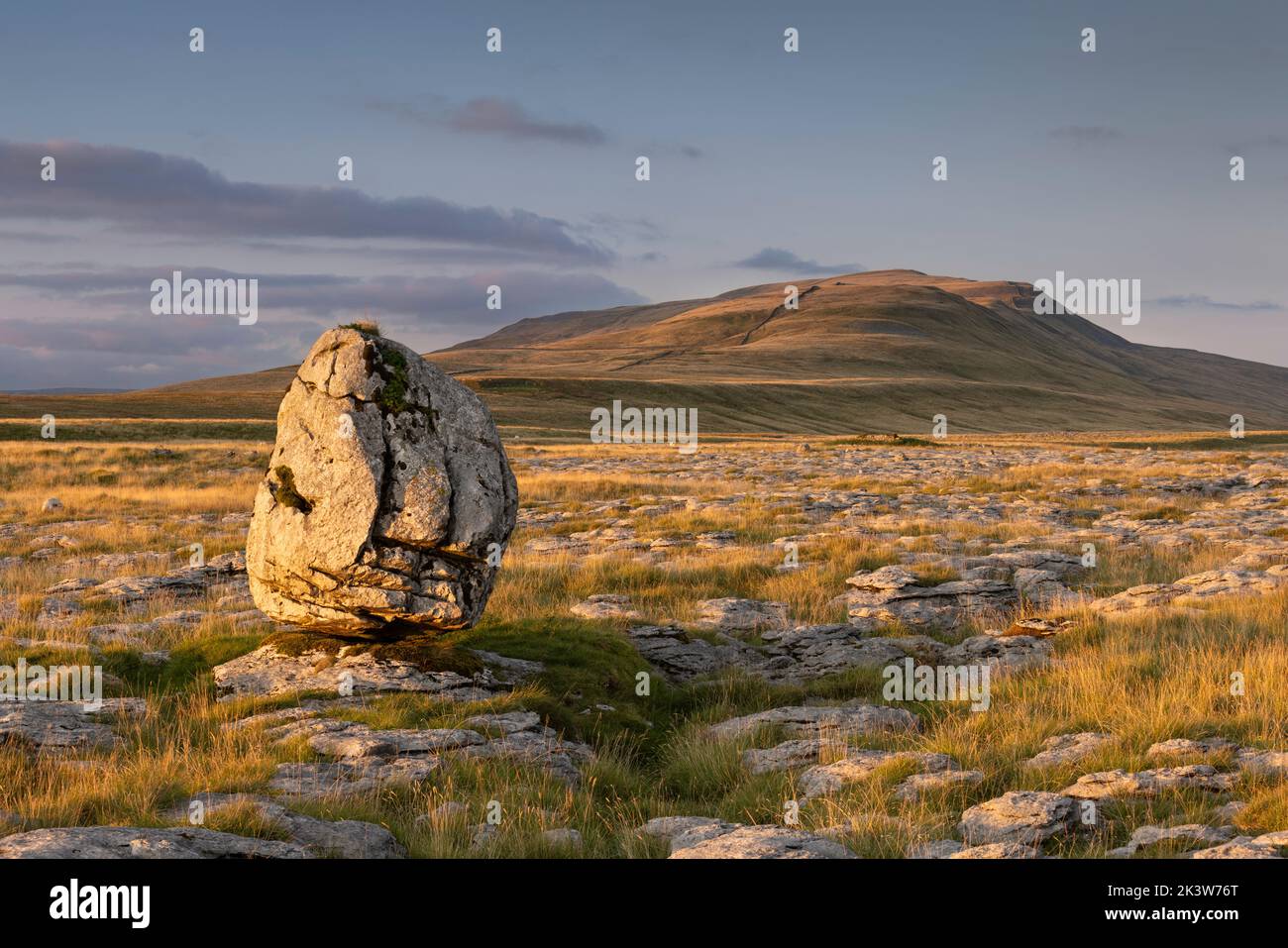 A large boulder standing on limestone pavement, on the slopes of ...