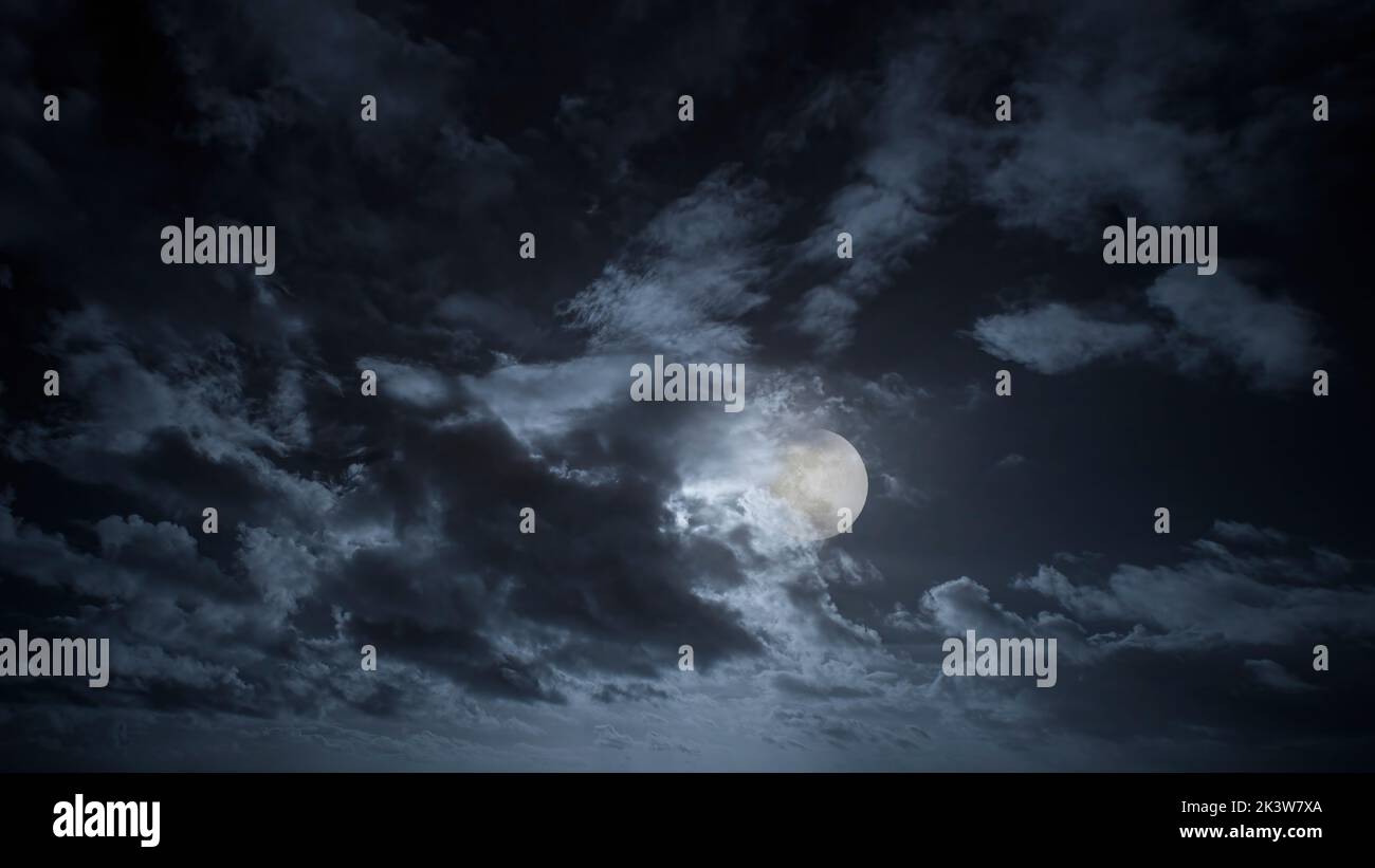 Rising full moon in a dramatic cloudy full moon night Stock Photo - Alamy