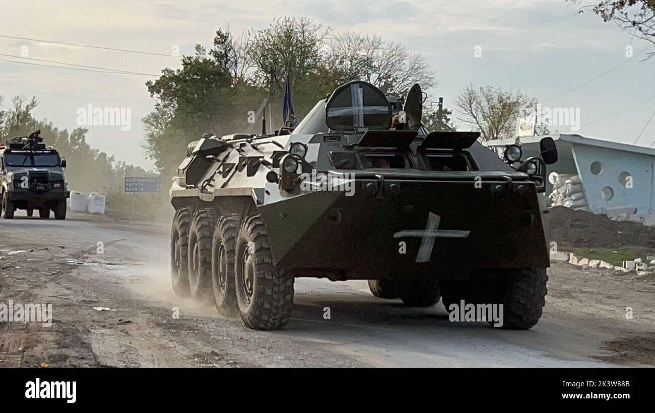 Ukrainian military vehicles drive through the streets of the city of ...