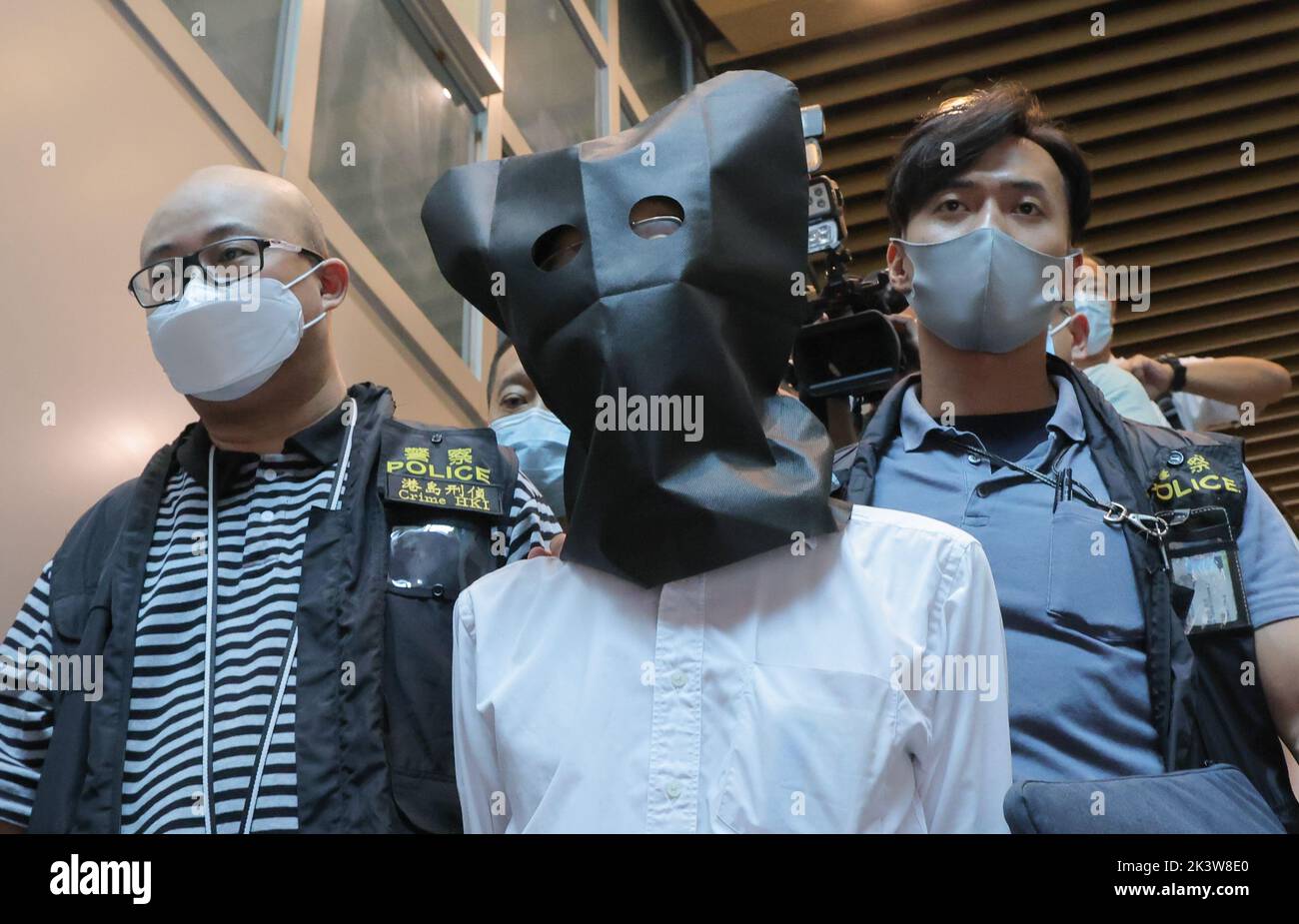 Police officers escort a suspect from the clinic of Doctor Wong Ping ...
