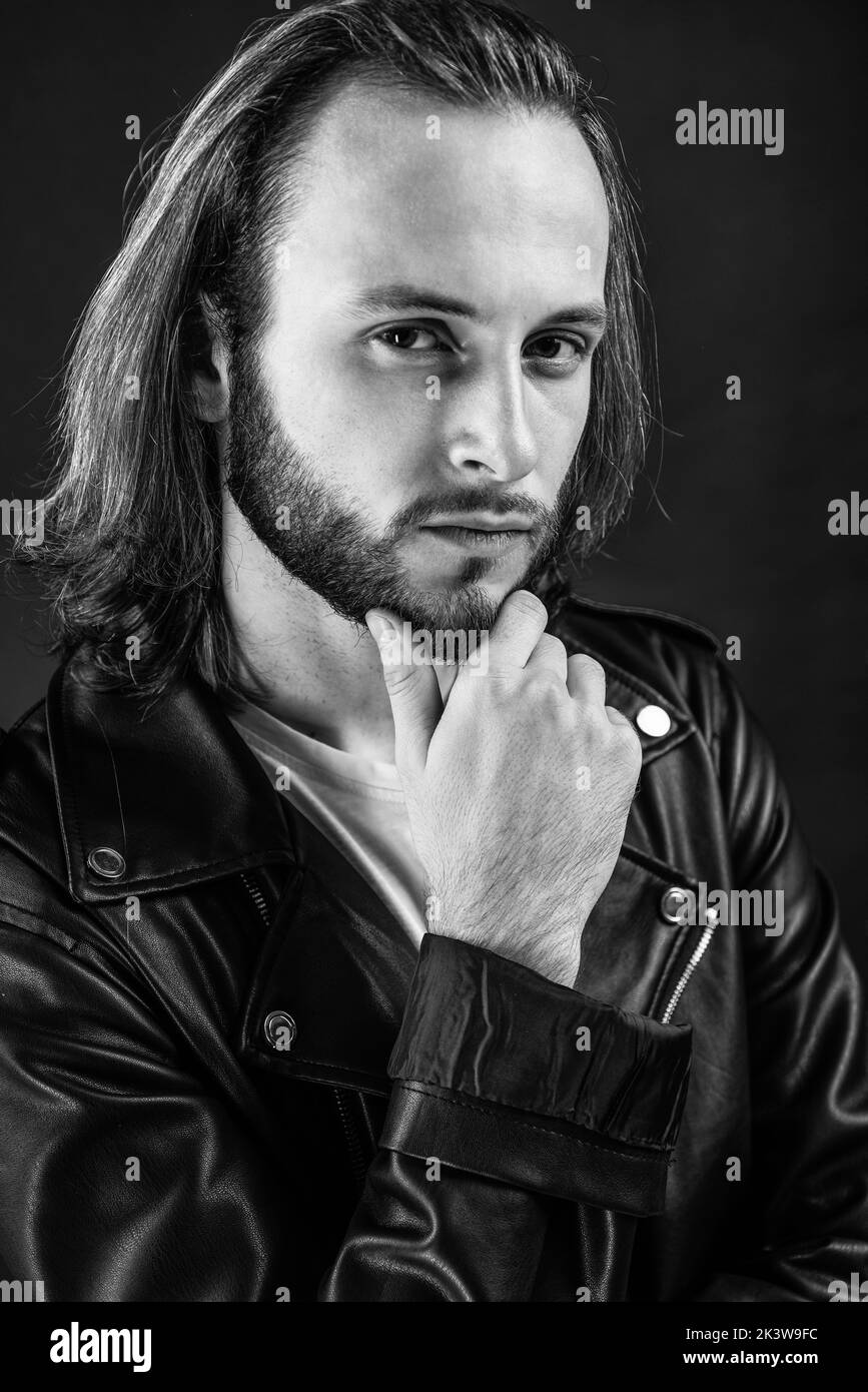 bearded man biker in leather jacket with long hair, beard care Stock ...
