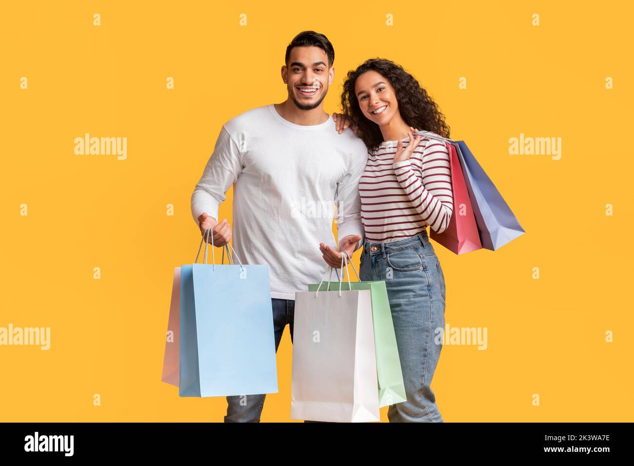 Middle Eastern Couple Posing With Shopping Bags In Hands Over Yellow ...
