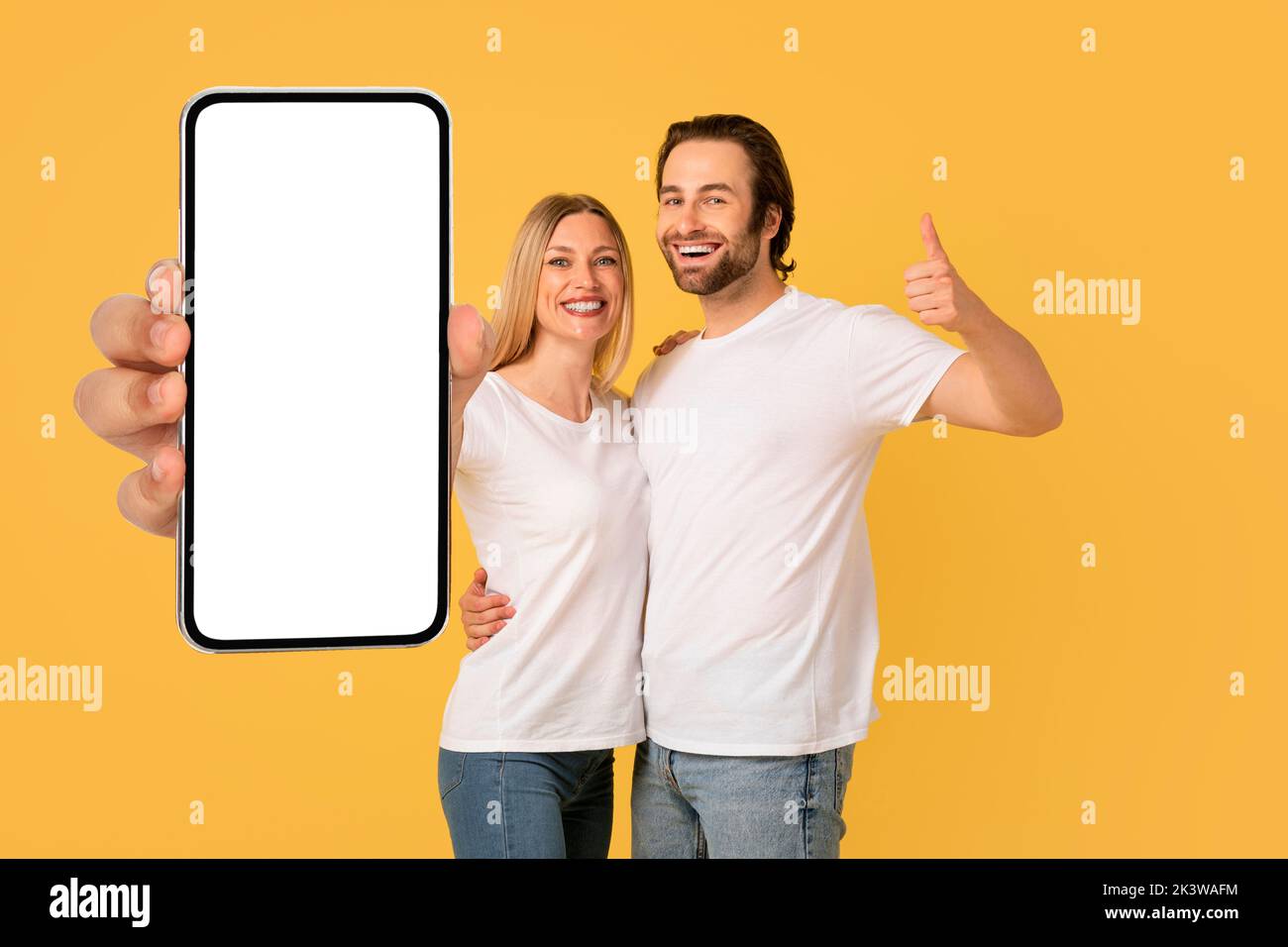 Happy young caucasian couple in white t-shirts make thumb up gesture ...