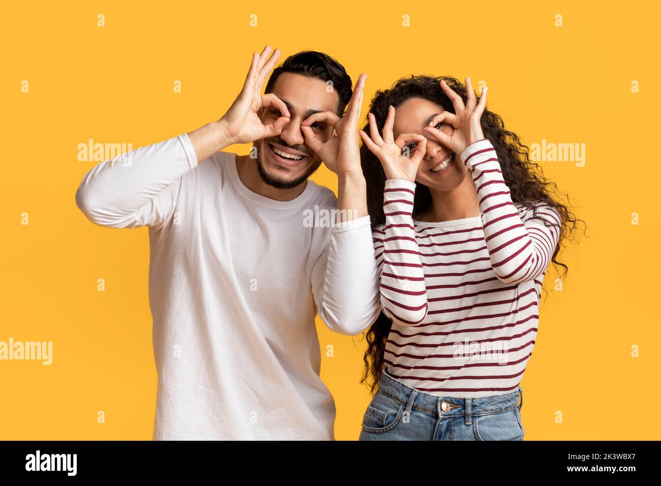 Cheerful middle eastern couple making funny glasses with fingers Stock ...