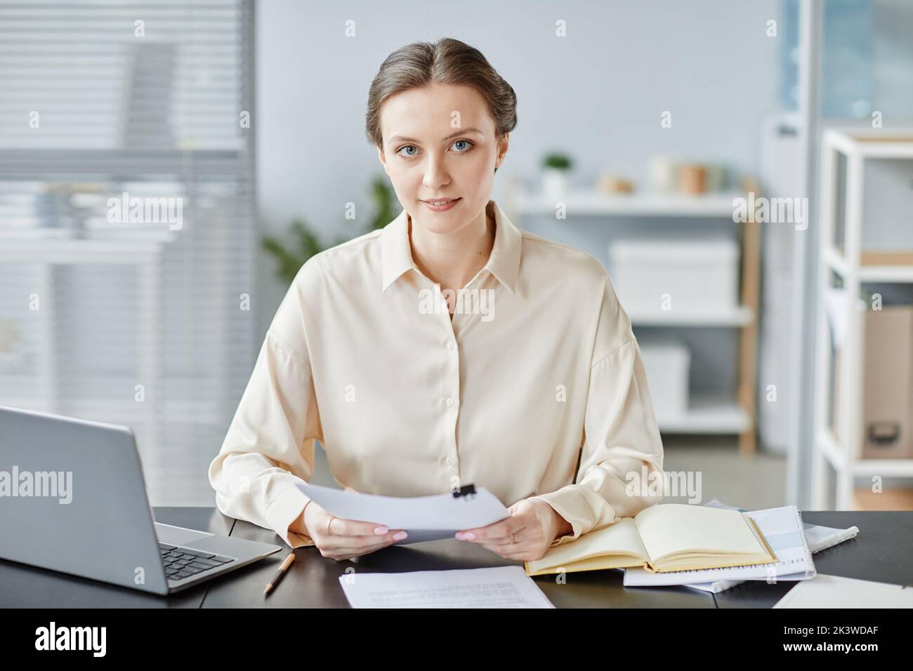 Minimal portrait of young successful businesswoman looking at camera ...
