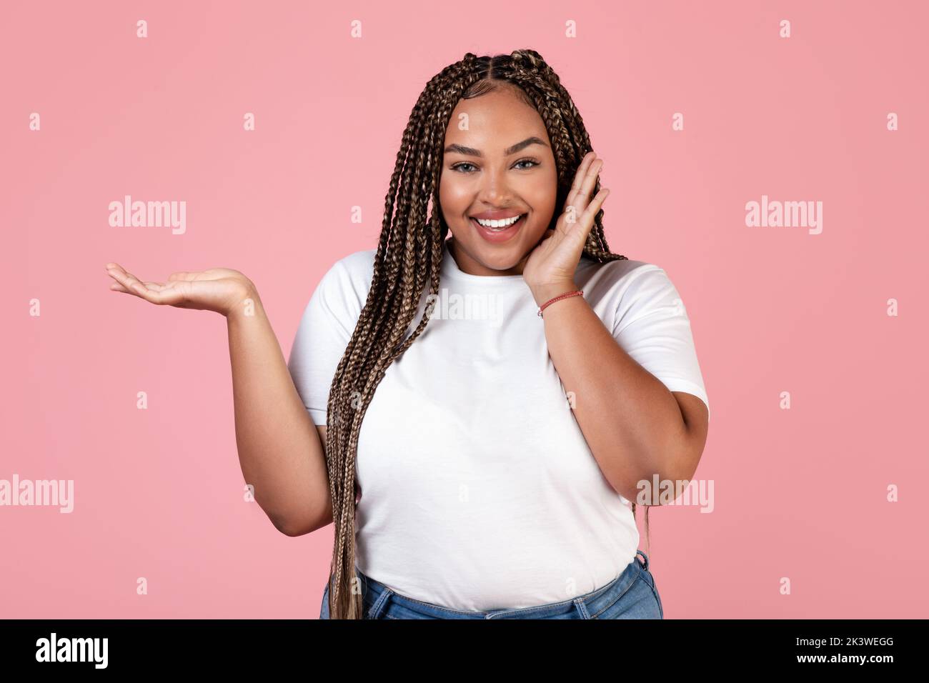 African Obese Woman Holding Invisible Product On Hand, Pink Background ...