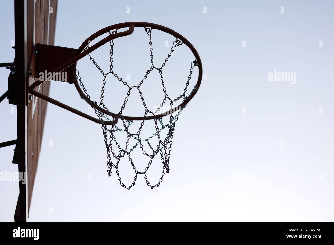 silhouette of basketball hoop with metal net on wooden backboard on ...