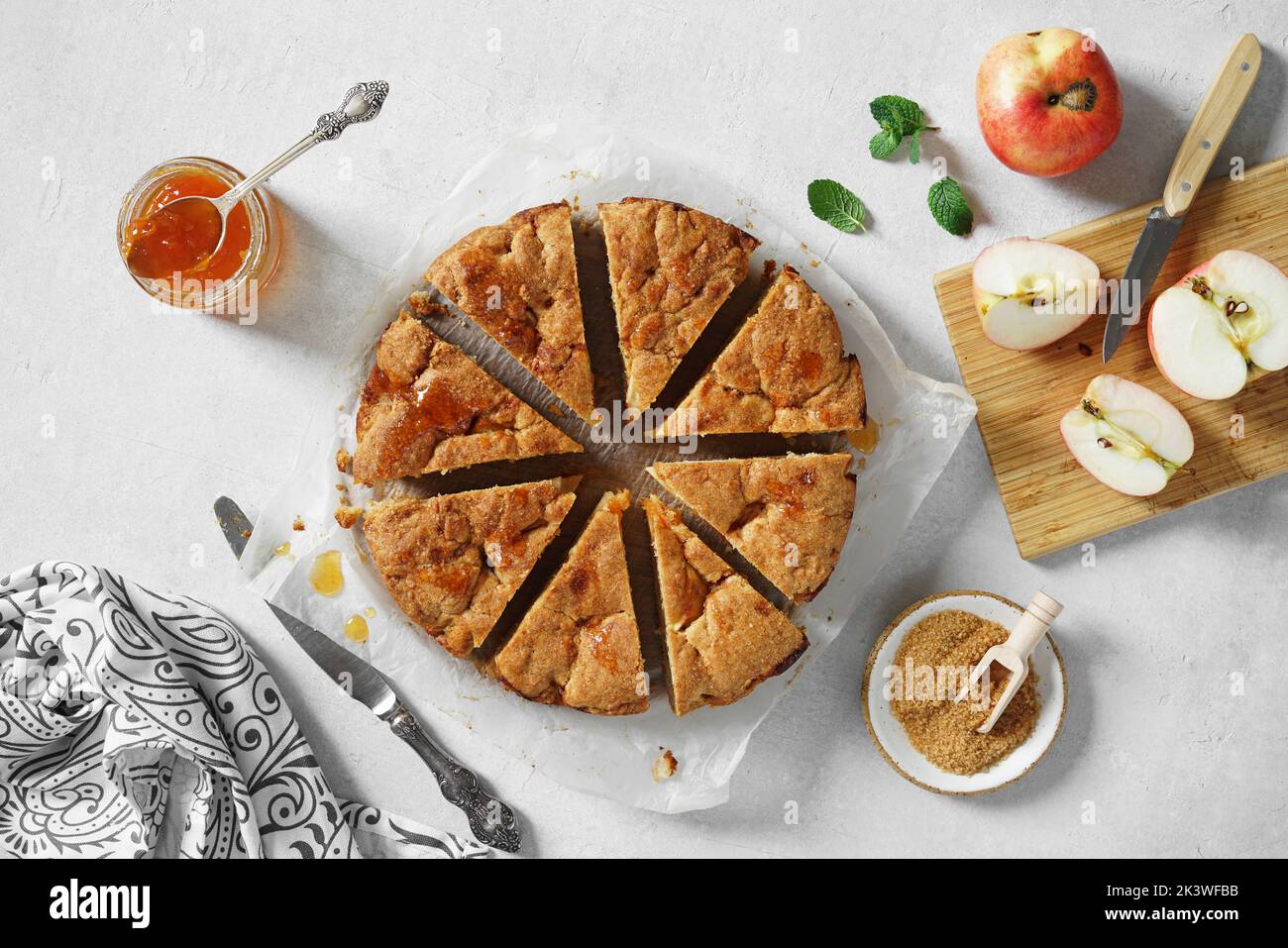 Freshly baked delicious apple pie with apricot jam cutting into pieces ...
