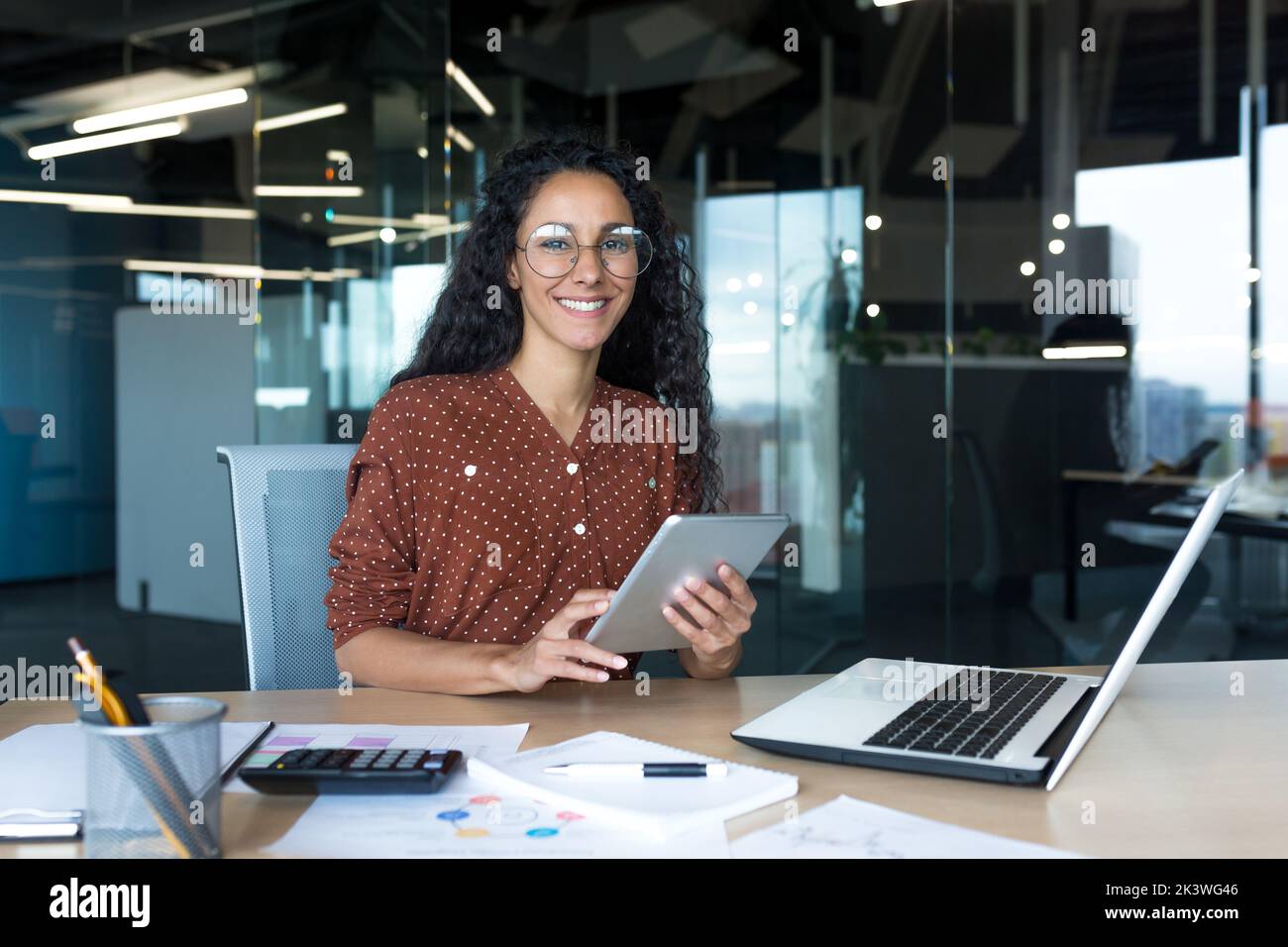 Happy and successful hispanic woman working inside modern office ...