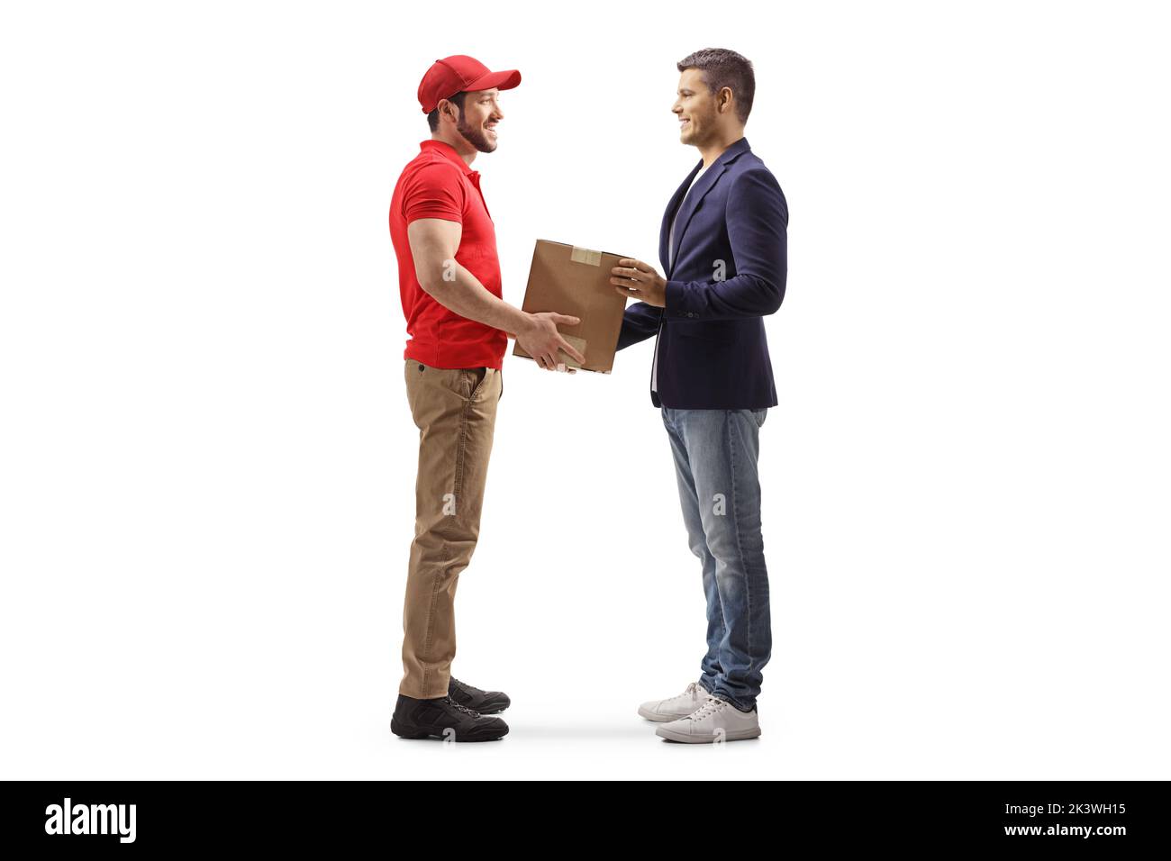 Full length profile shot of a delivery man handing a cardboard box to a ...
