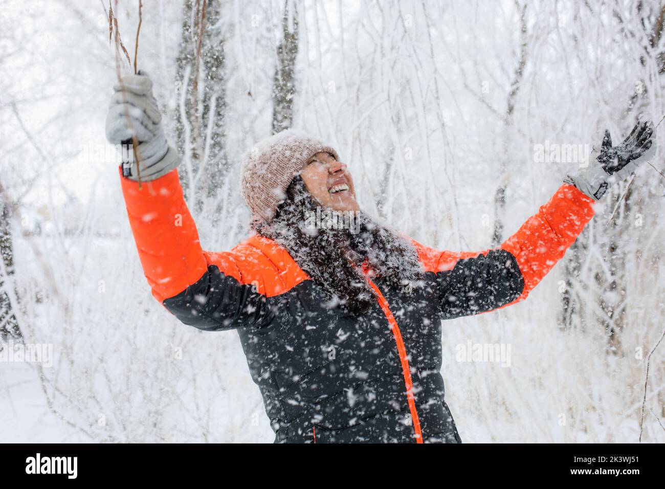 Joyful middle aged woman with widely outstretched arms looking up at ...