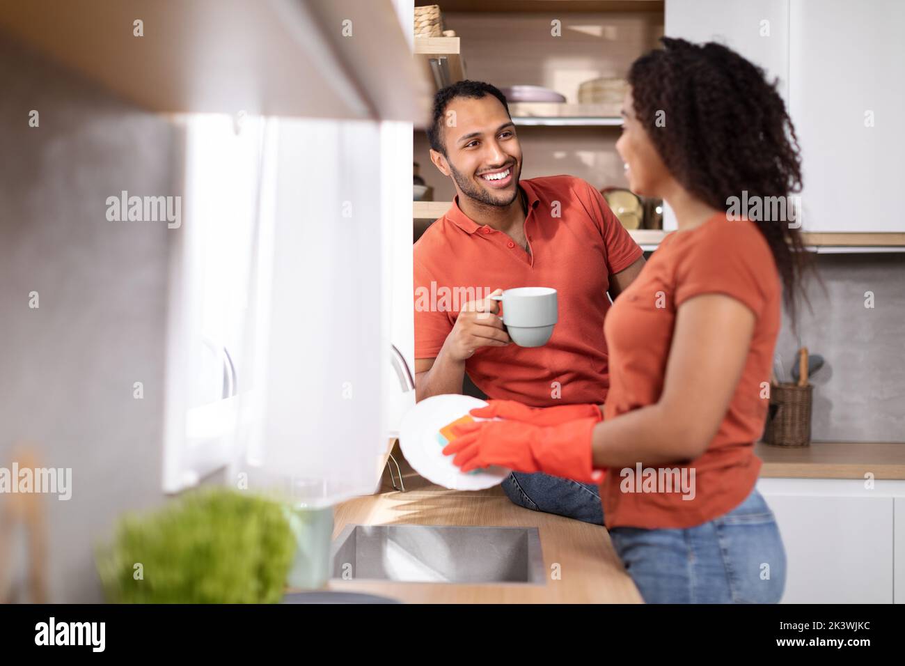 Smiling Millennial Black Guy With Coffee Cup Talk With Lady Wife In