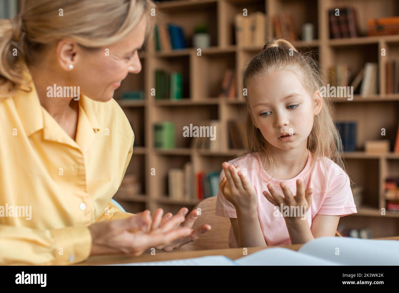Clever little girl counting on fingers, studying with private teacher ...
