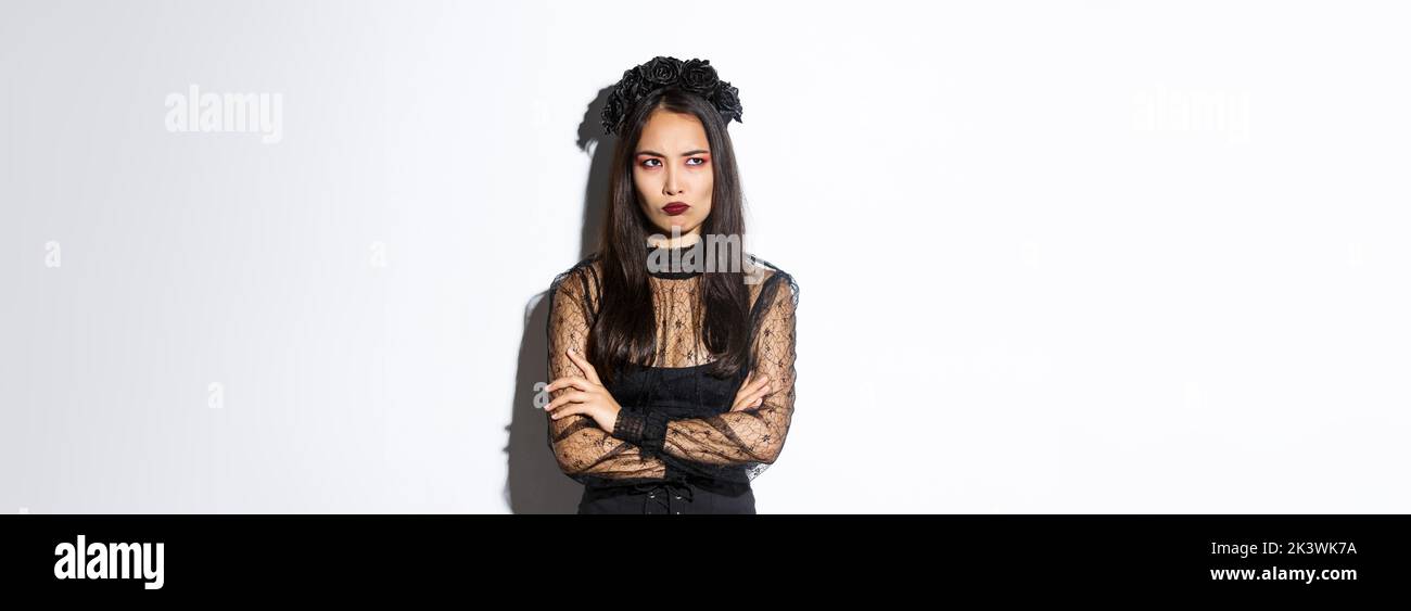 Image of mad asian woman in gothic lace dress and wreat, cross arms ...