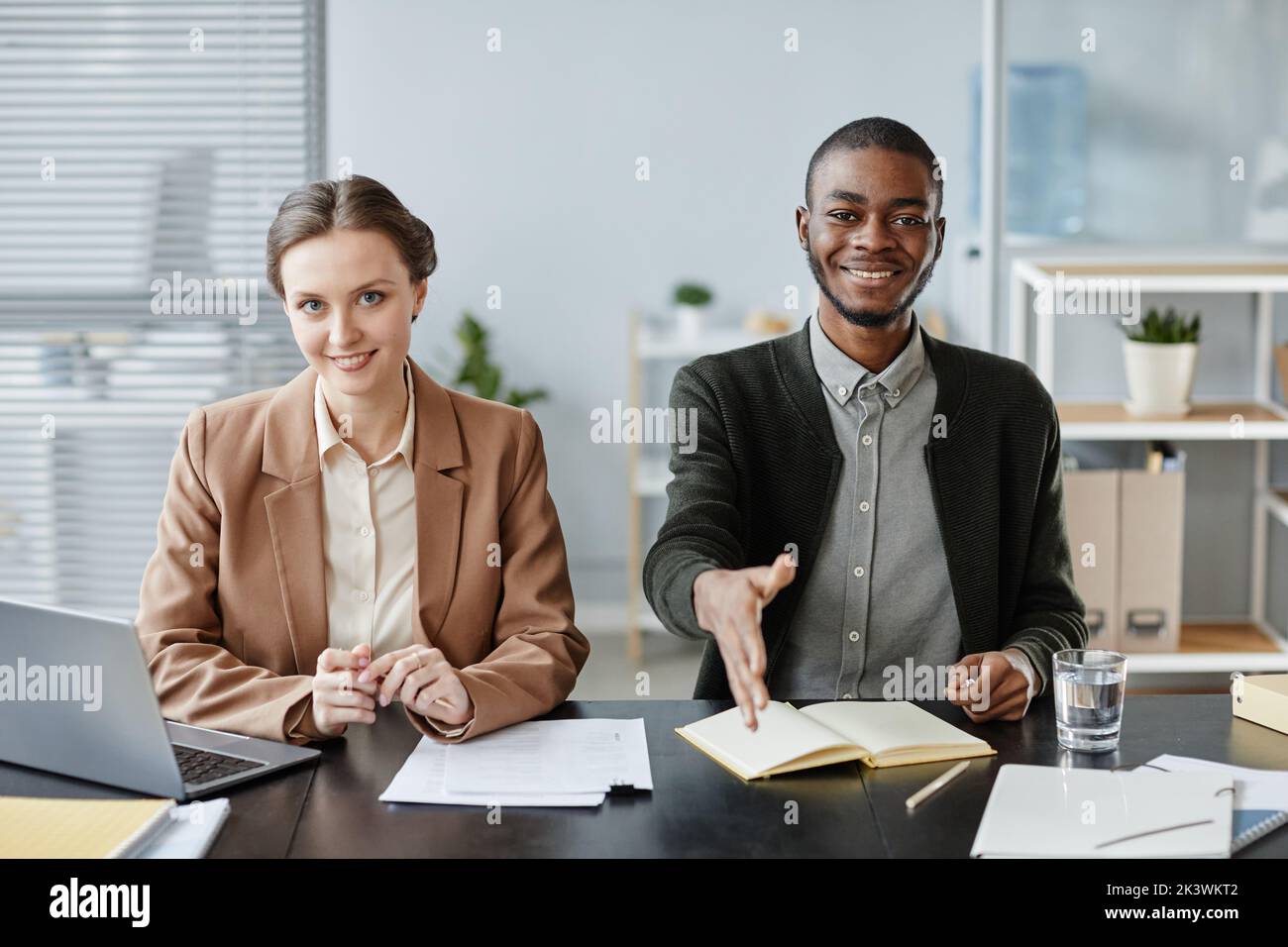 Portrait of smiling HR team stretching hand to camera for greeting in ...