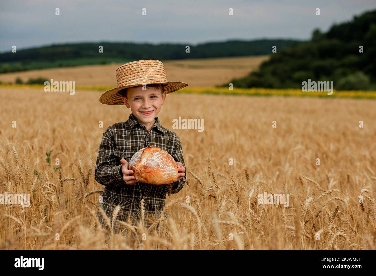 Little boy in the straw hat and shirt he held out his handing with ...