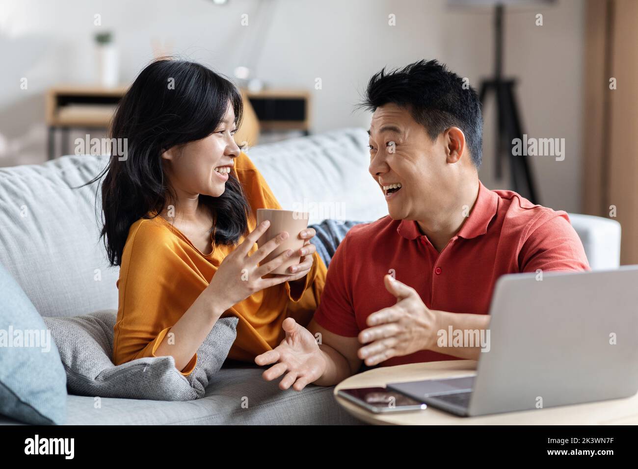 Cheerful korean couple planning vacation, using laptop Stock Photo - Alamy