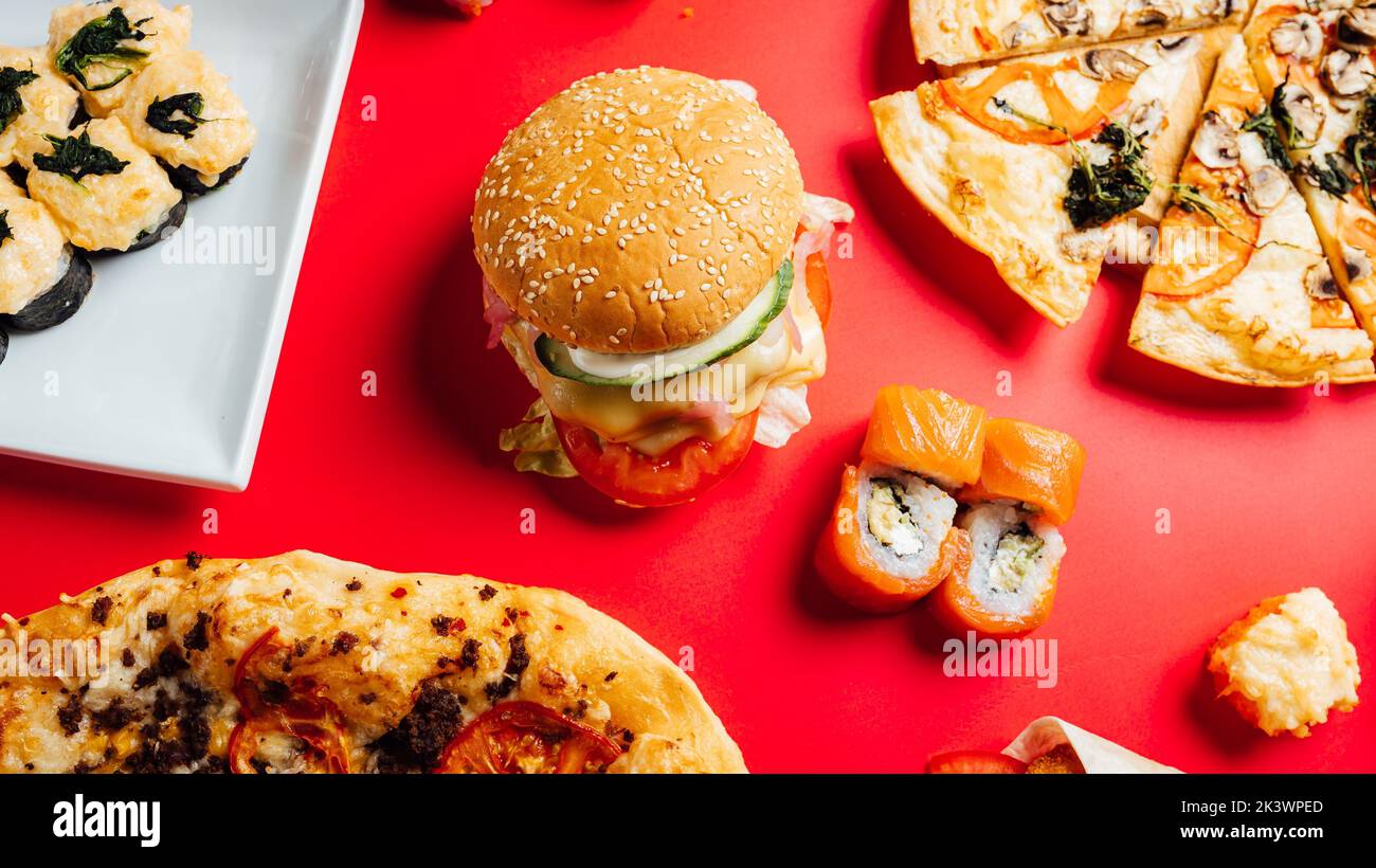 A top view of fast food delicacies including pizza, burger and sushi ...