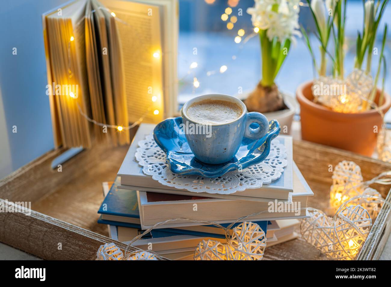 Coffee cup, open book, spring flowers, sparkle lighting garland on ...