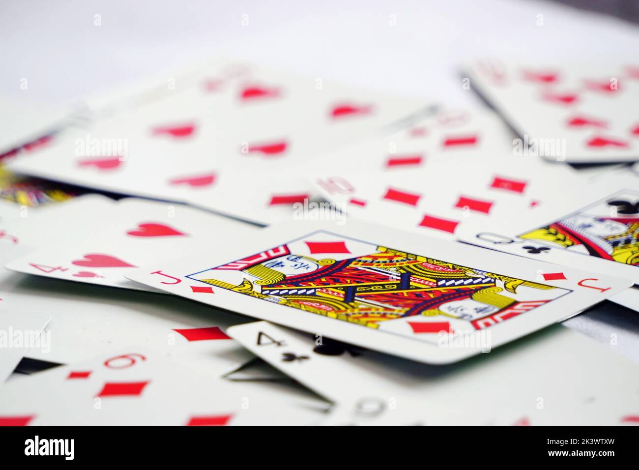 The close-up view of a pile of playing cards over the white surface ...